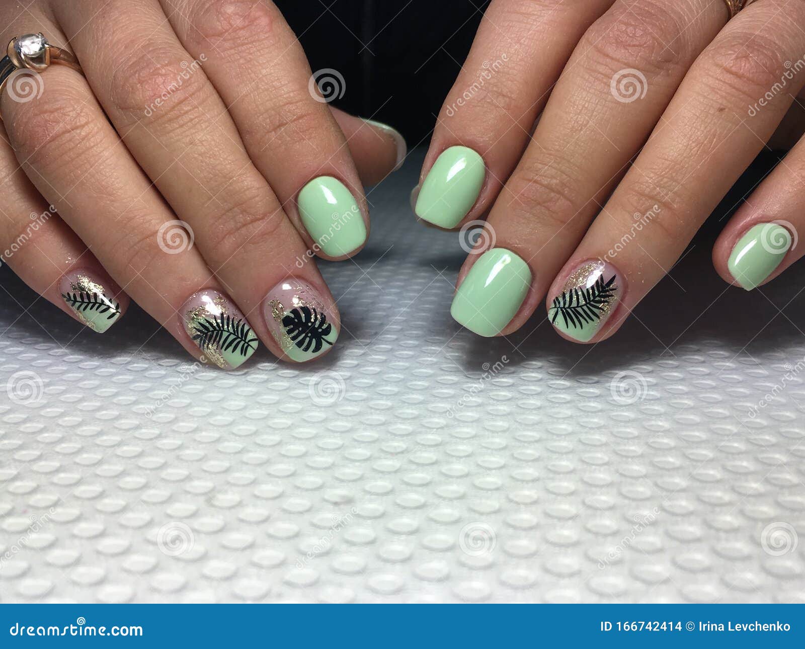 Trendy Green Manicure with a Stylish Design and Black Leaf Stock Photo ...