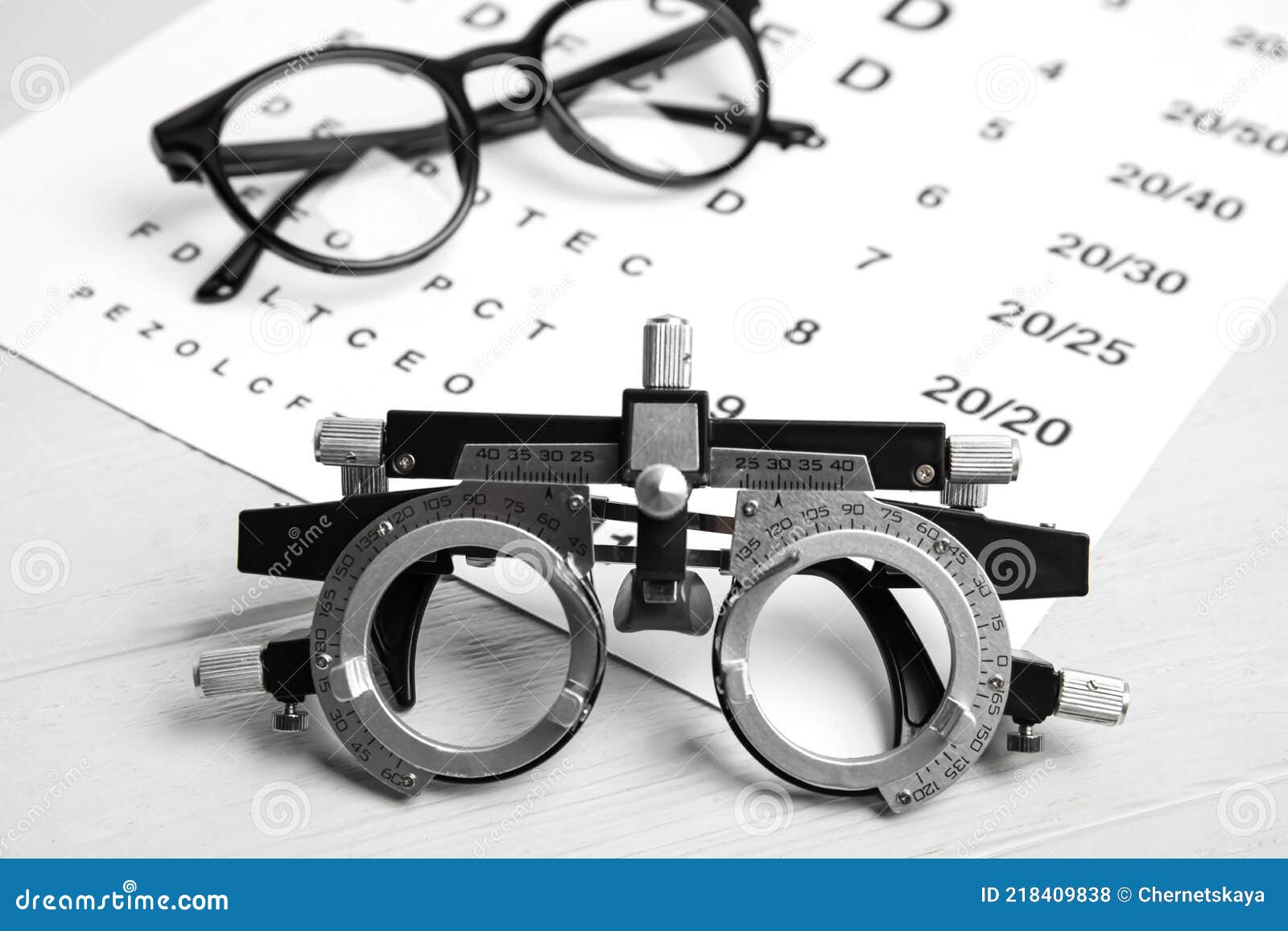 Trial Frame, Eye Chart Test and Glasses on White Wooden Table ...