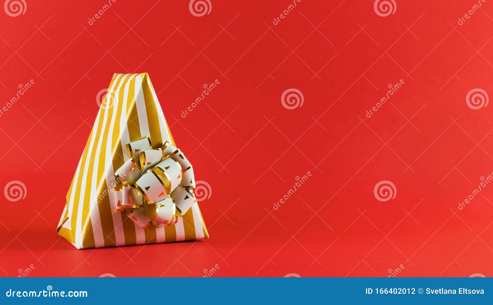 Triangular Gift Box in Striped Wrapping Paper with Bow on Fiery Red ...