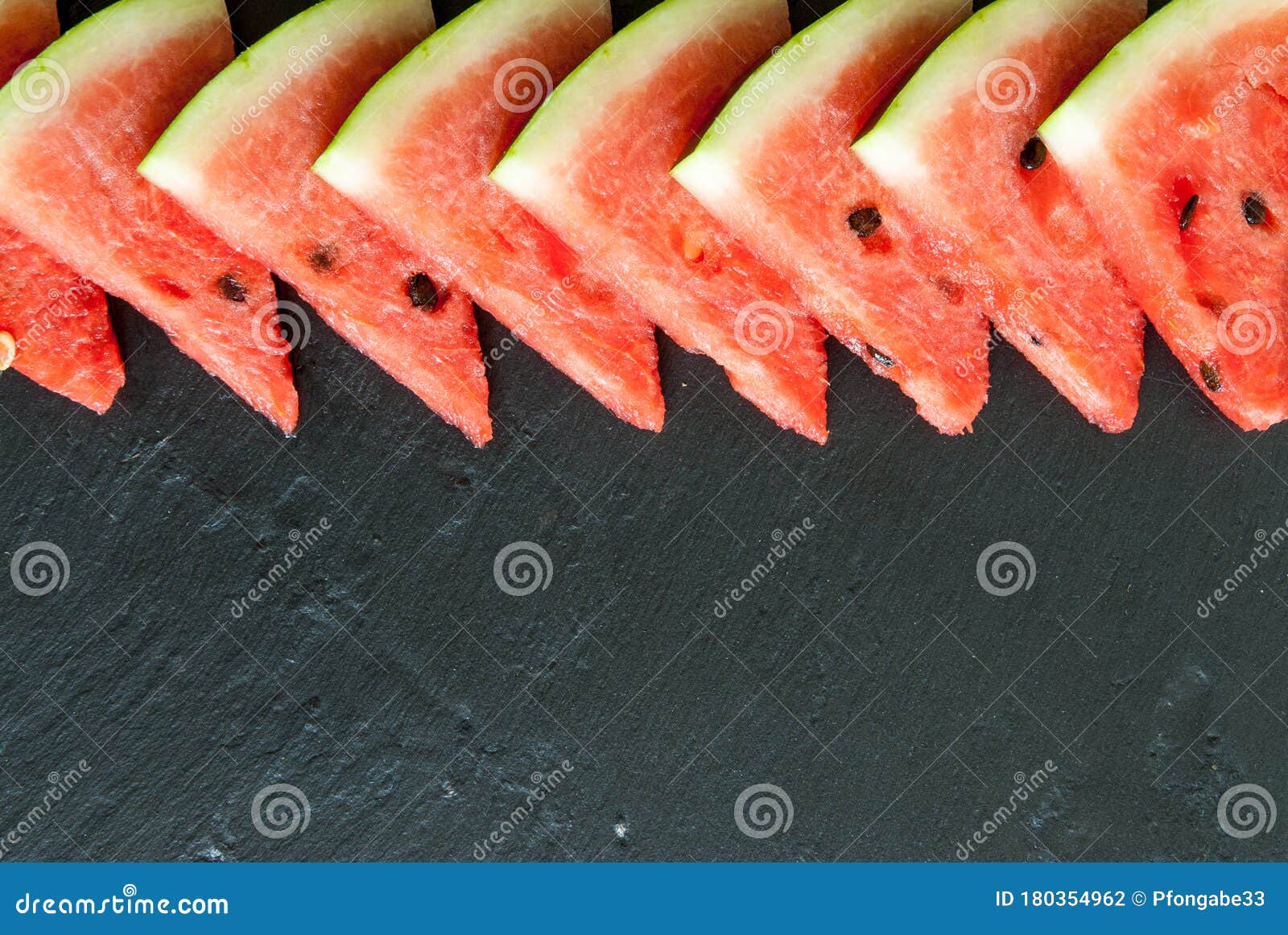 Triangular Pieces of Water Melon Arranged in Line on Black with Copy ...