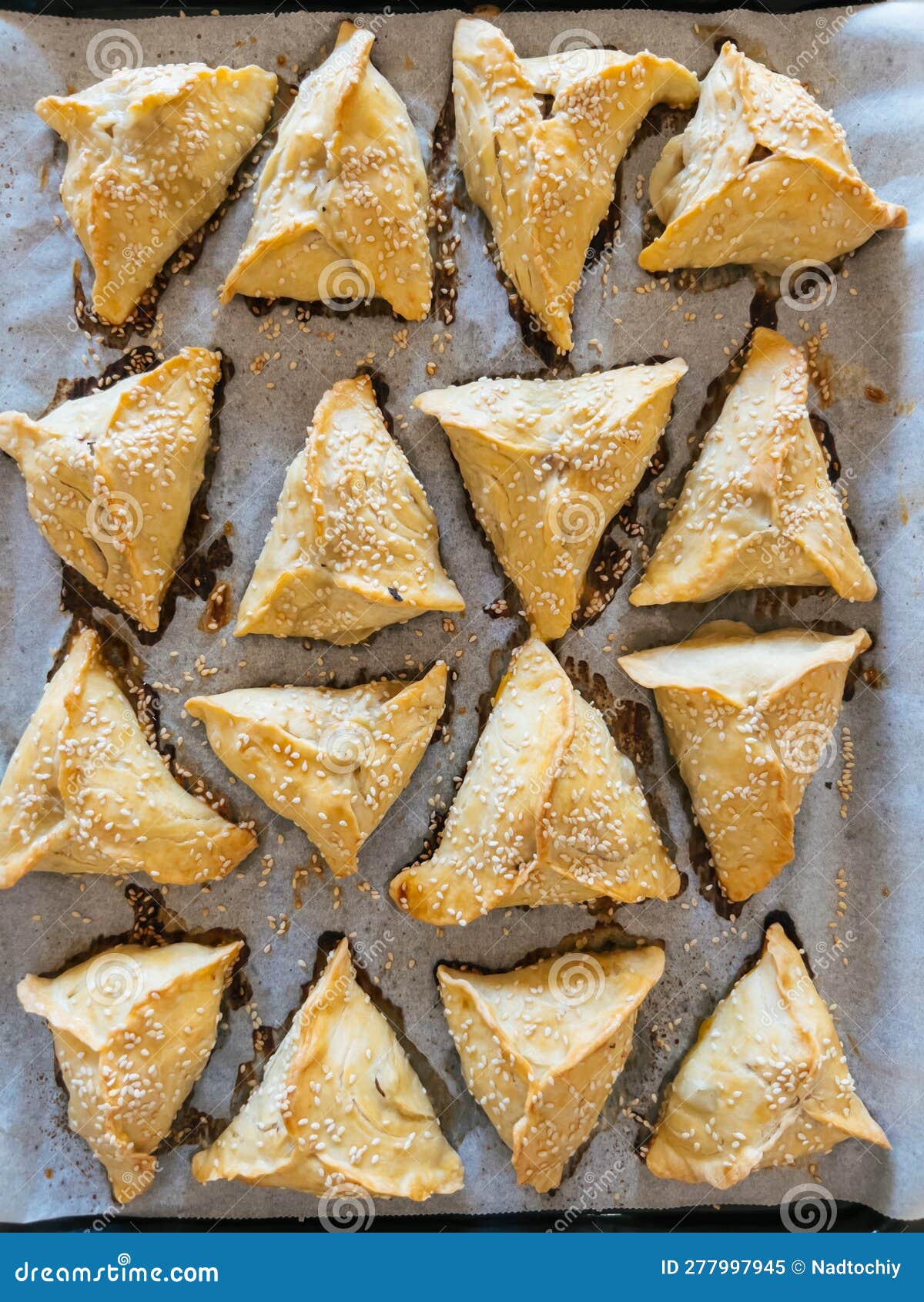 Triangular Puffs with Filling Sprinkled with Sesame Seeds Lie on a ...