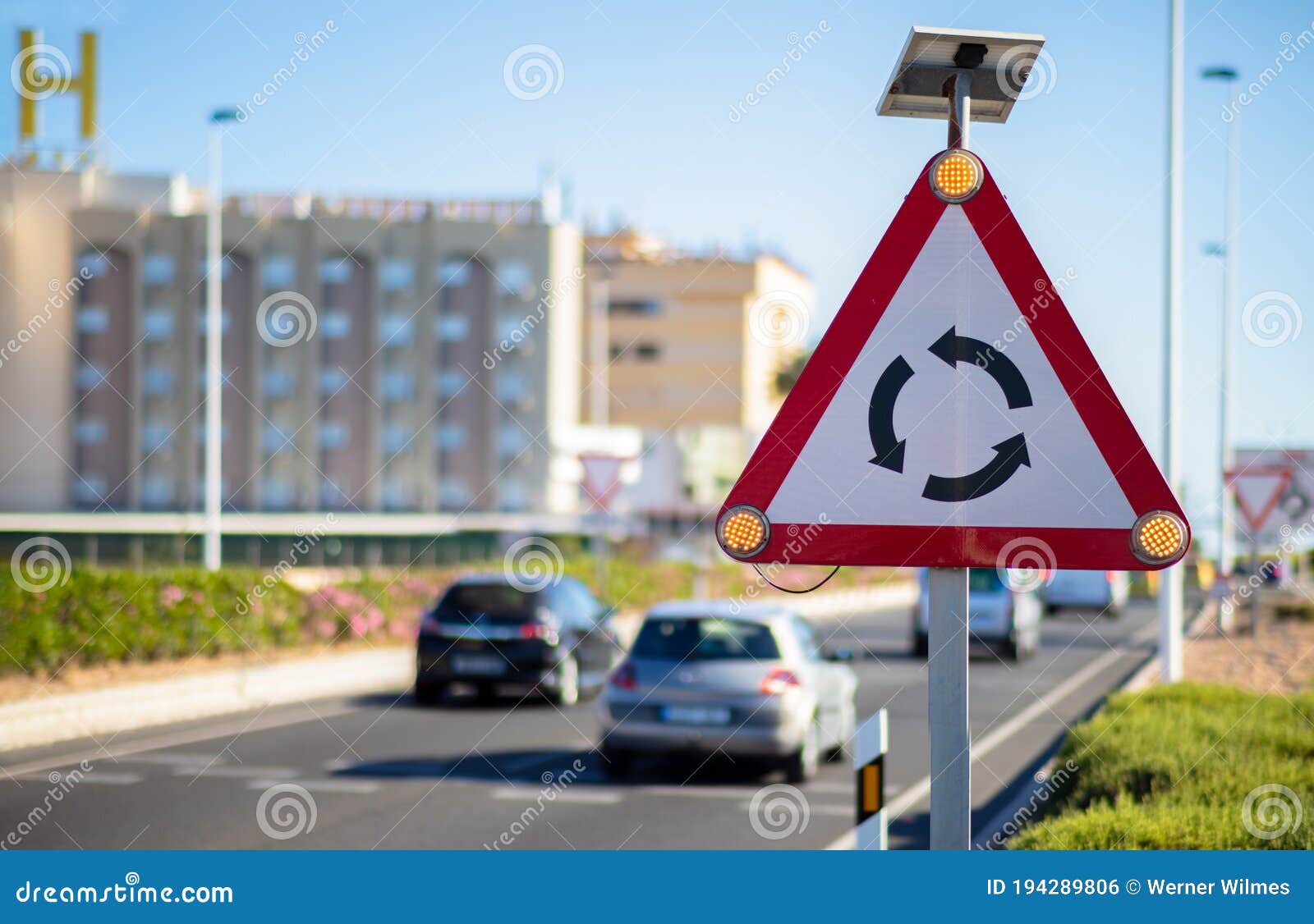 A Triangular Warning Sign with Flashing Lights Stands in Front of a ...