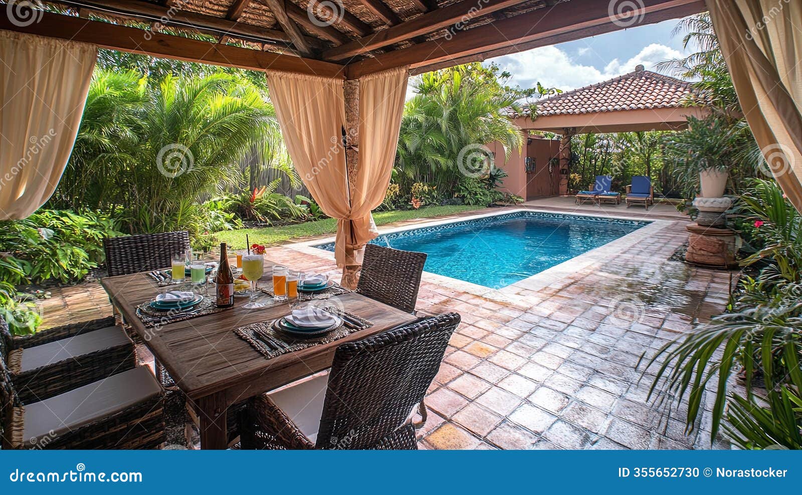 A Tropical Poolside Cabana with Curtains and a Table Set with Fresh ...