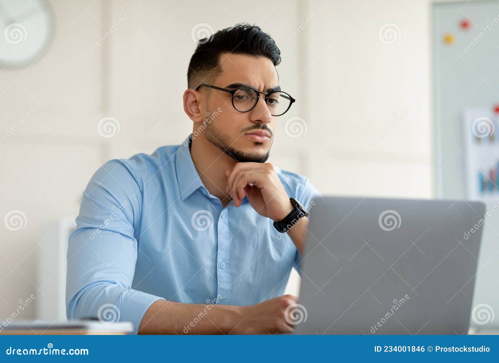 Troubled Arab Office Worker Sitting at Table, Looking at Laptop Screen ...