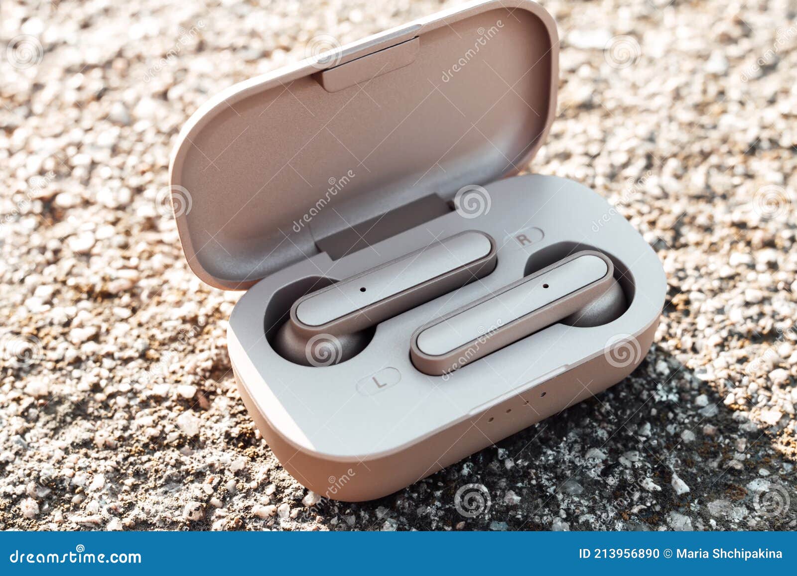 True Wireless Earbuds in Case on Natural Stone Background, Top View ...