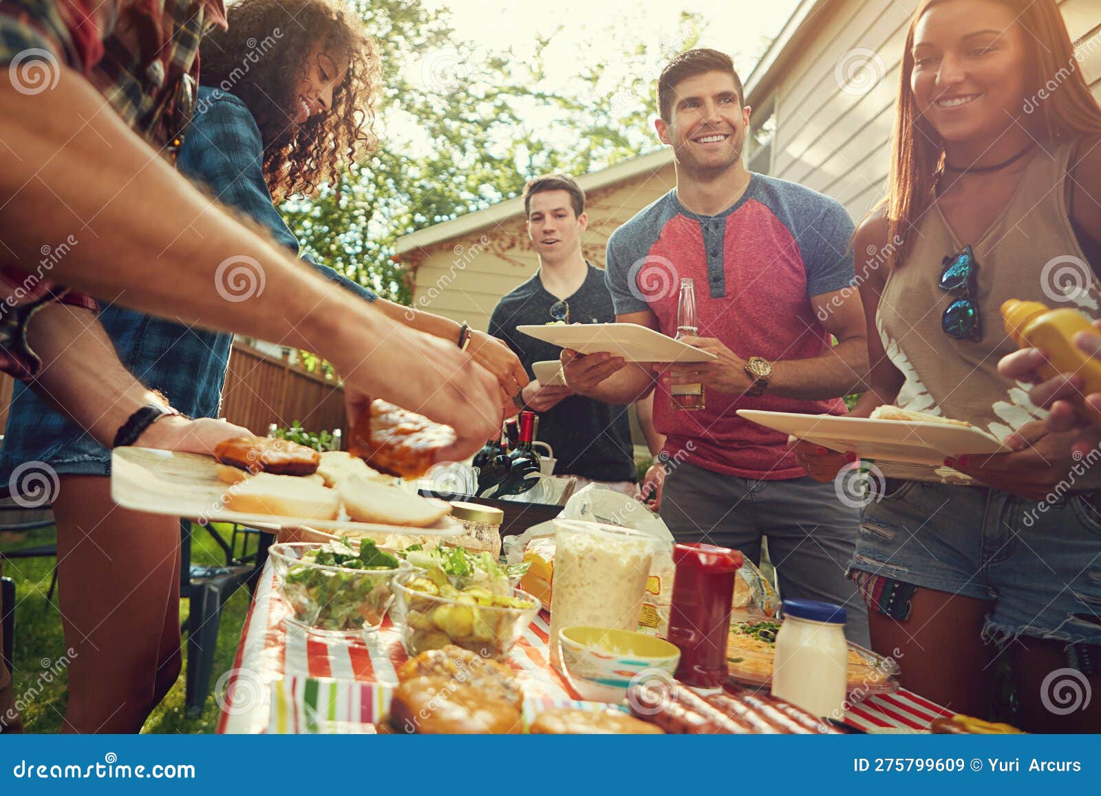 Tuck in, Guys. a Group of Friends Having Lunch in Their Backyard. Stock ...