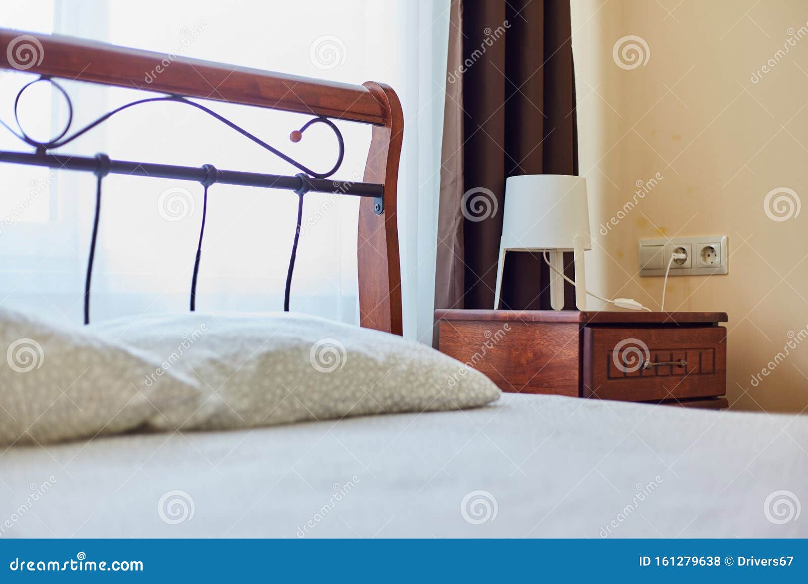 A Tucked-in Bed with a Bedside Table Indoors. Stock Photo - Image of ...
