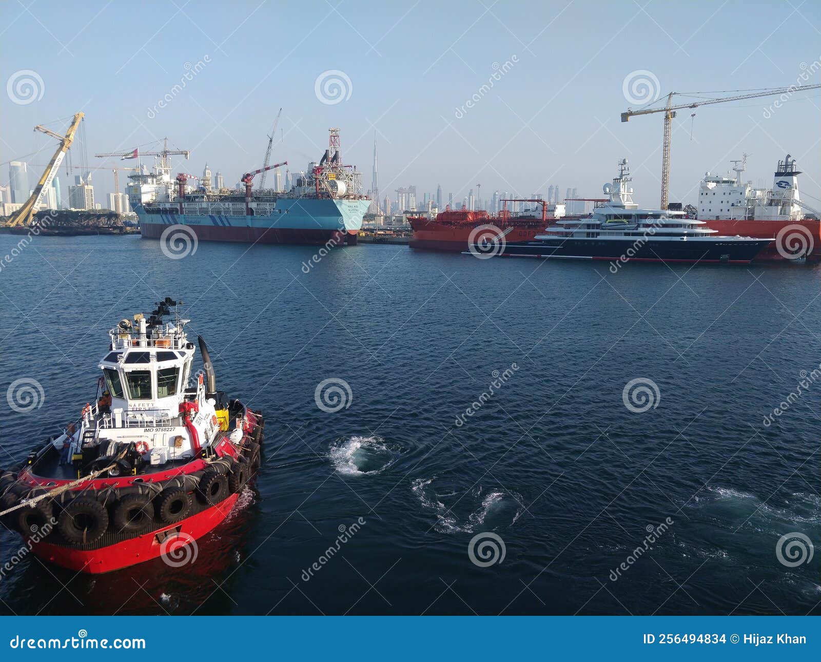 A Tug Pulling Ship and in Background There Lot Ships Berthed Stock ...