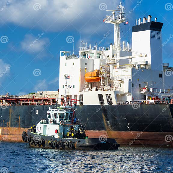 Tugboat Guiding a Huge Cargo Ship Stock Photo - Image of commercial ...