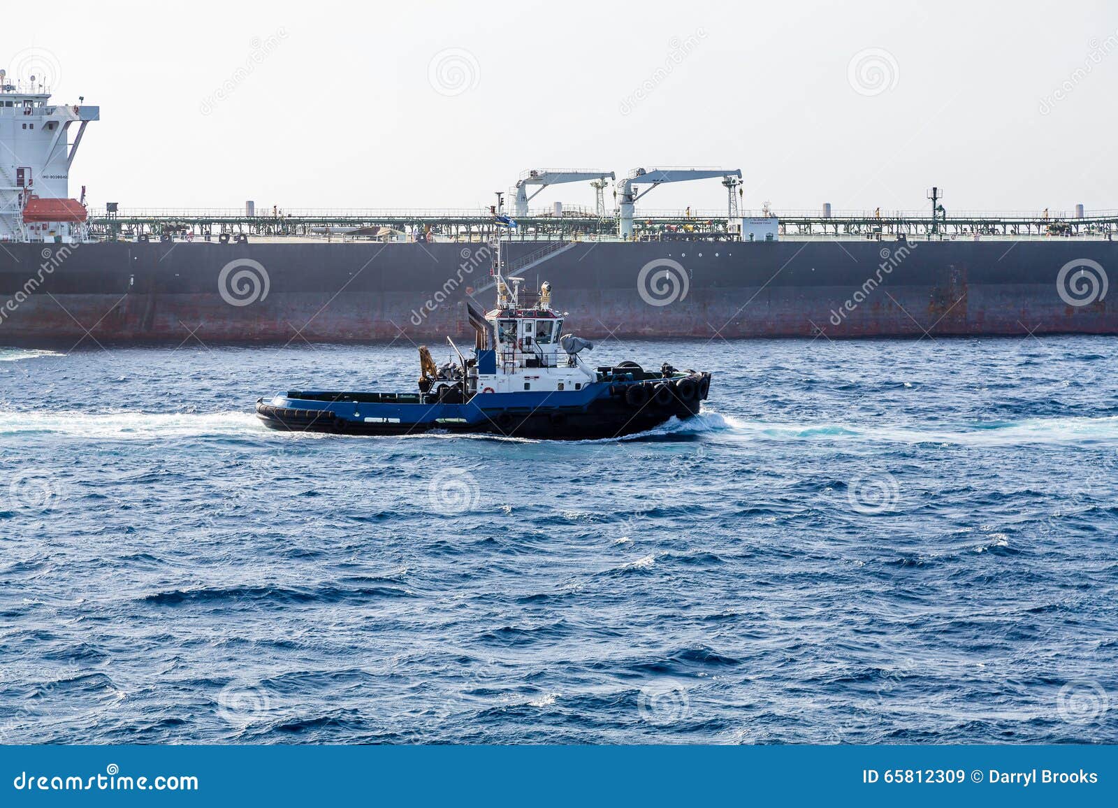 Tugboat by Massive Tanker stock image. Image of maritime - 65812309