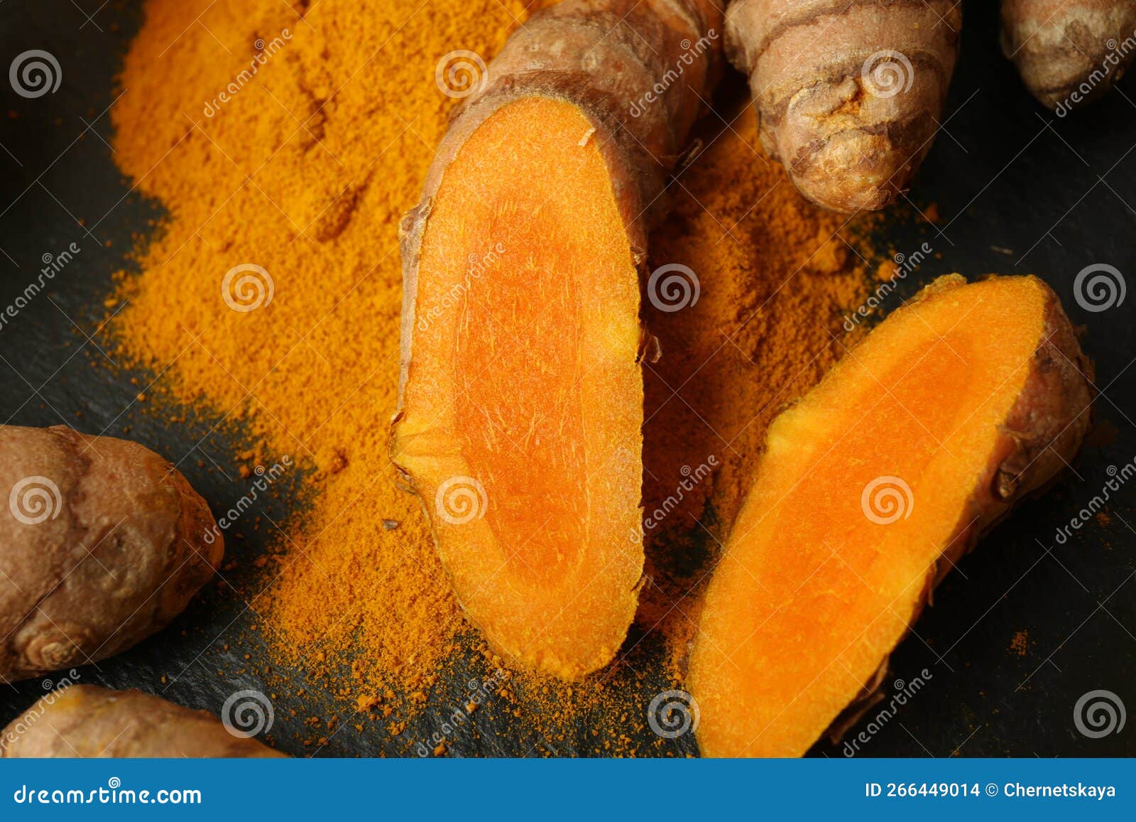 Turmeric Roots and Powder on Black Textured Table, Closeup Stock Photo ...