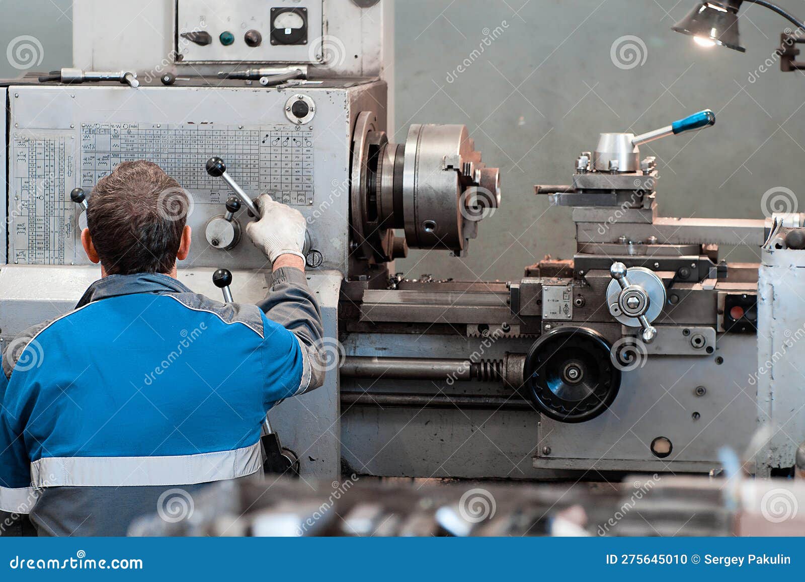 Turner at Lathe in Workplace. View of Worker from Back. Metal ...