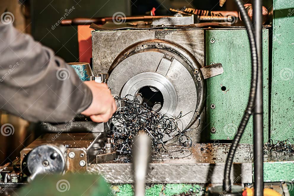 The Turner Removes Excess Chips with a Hook when Processing Metal on a ...