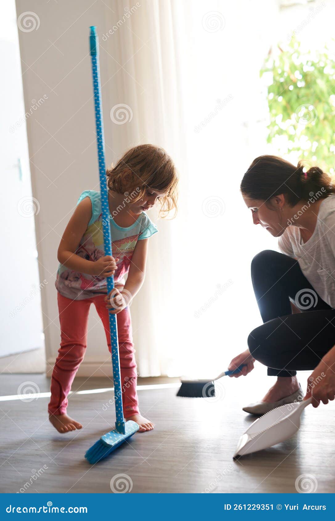 Turning Housework into Teamwork. a Mother and Daughter Sweeping the ...