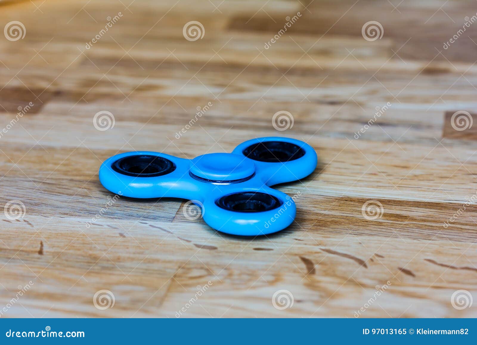 A Turquoise Fidget Spinner Lying on Wood Stock Image - Image of ...