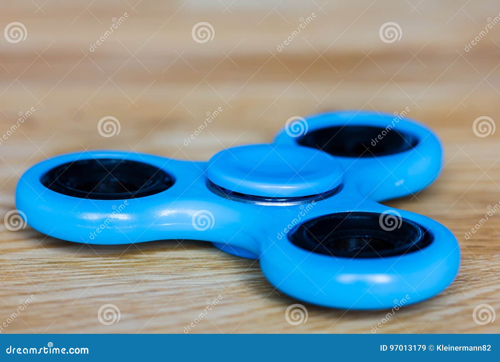 A Turquoise Fidget Spinner Lying on Wood Stock Image - Image of iron ...