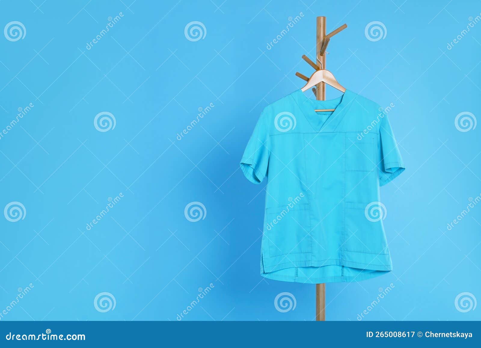 Turquoise Medical Uniform Hanging on Rack Against Light Blue Background ...