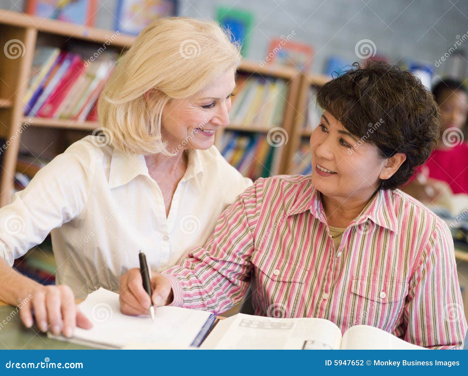 Tutor Assisting Mature Student in Library Stock Photo - Image of ...