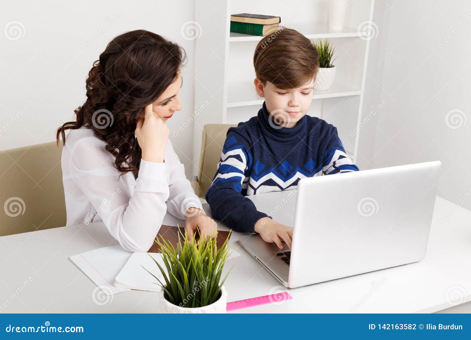 Tutor and the Boy Doing Homework in the White Classroom. Typing ...