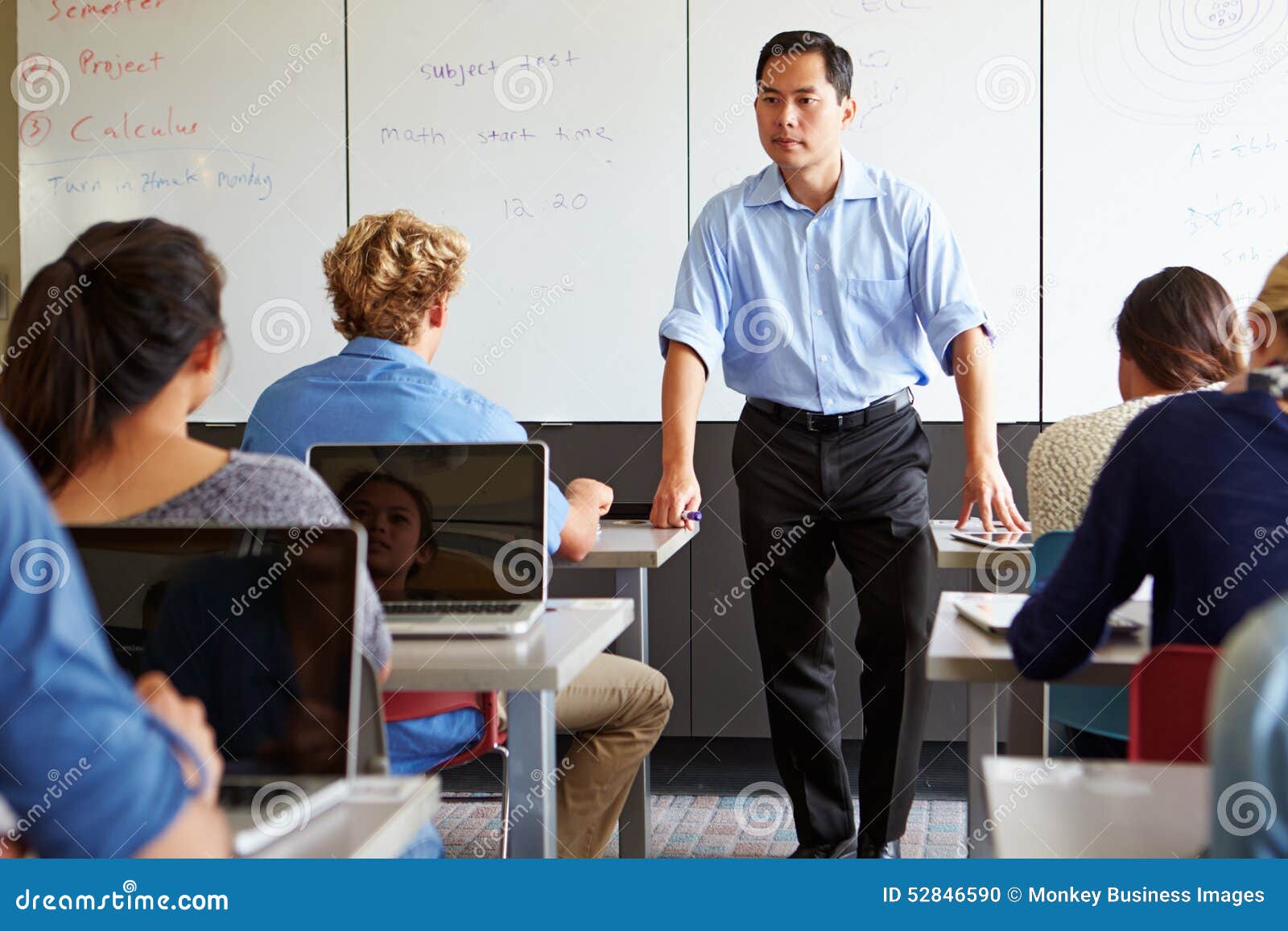 Tutor with High School Students in Class Using Laptops Stock Photo ...