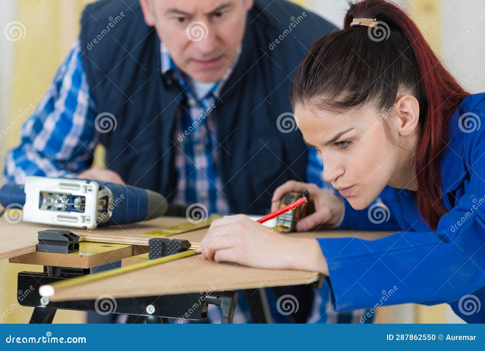 Tutor Watching Apprentice Measuring Wood Stock Photo - Image of ...