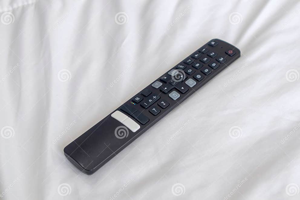A tv remote on the bed stock image. Image of bedding - 325318617