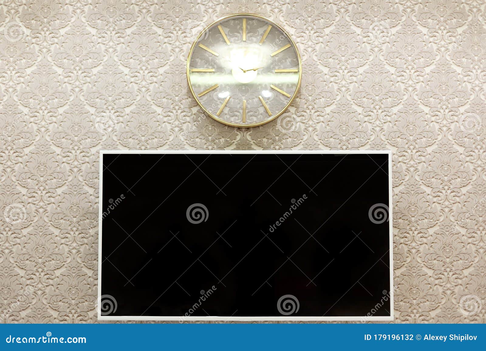 A TV with a White Frame is Hanging on the Wall. a Round Mechanical ...