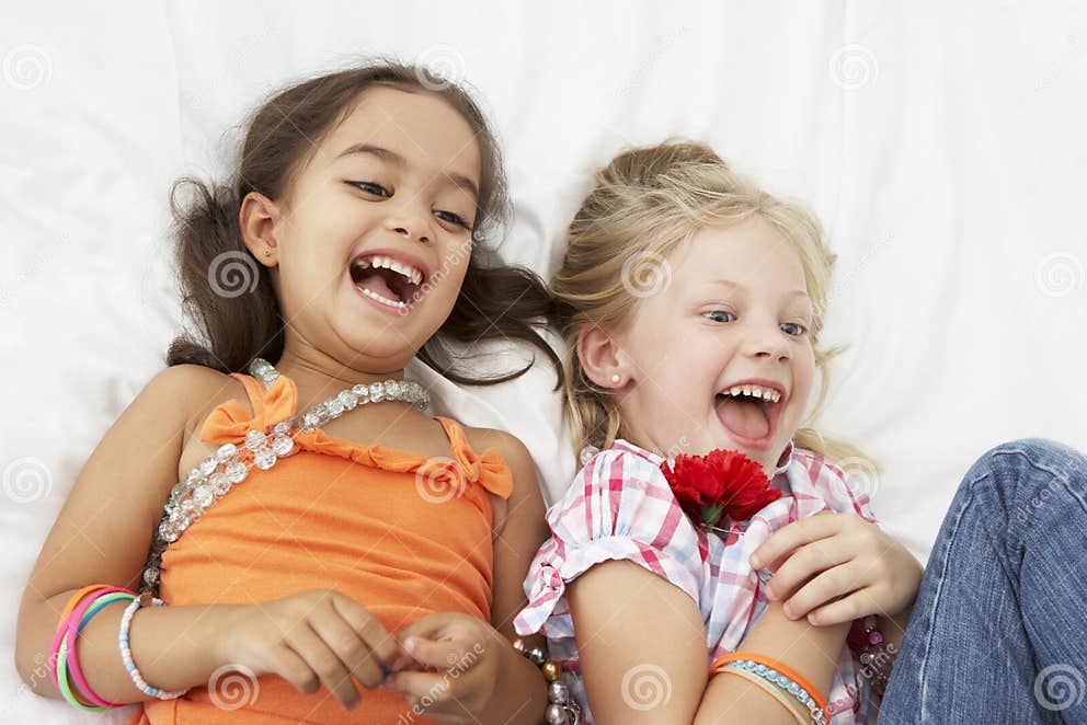 Twee Jonge Meisjes Die Omhoog Zich Samen In Slaapkamer Kleden Stock