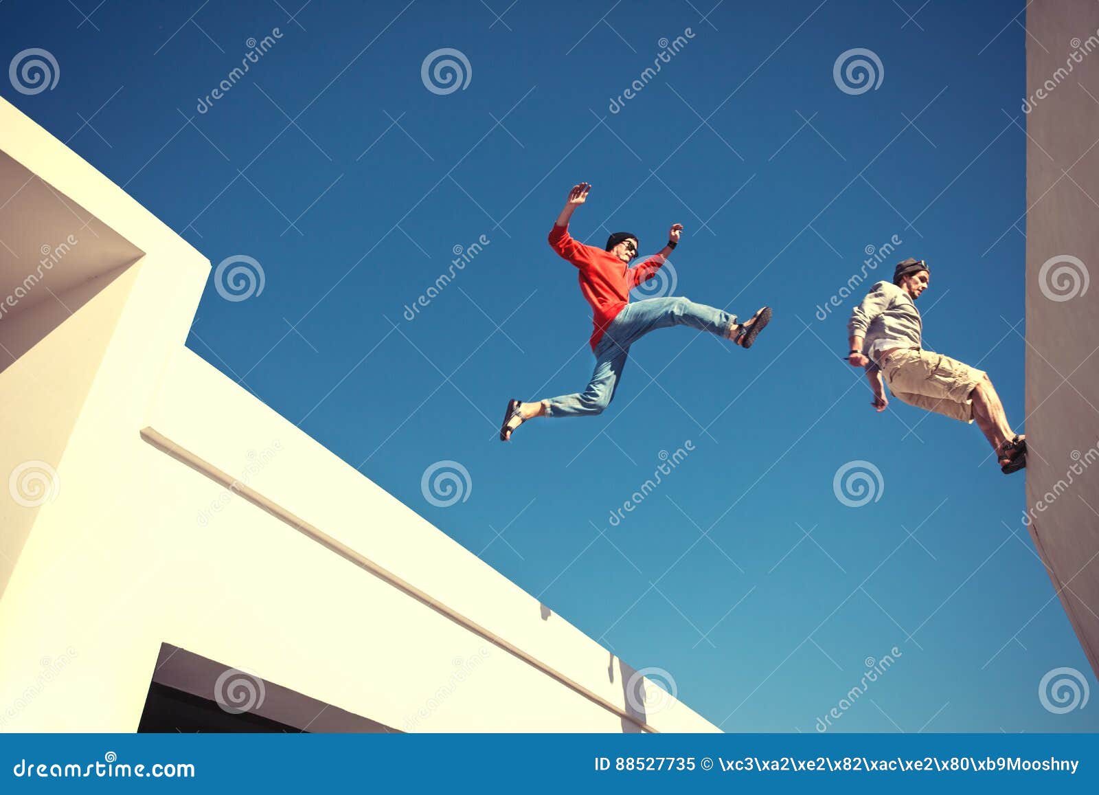 Twee Moedige Mensen Die Over Het Dak Springen Stock Afbeelding - Image ...