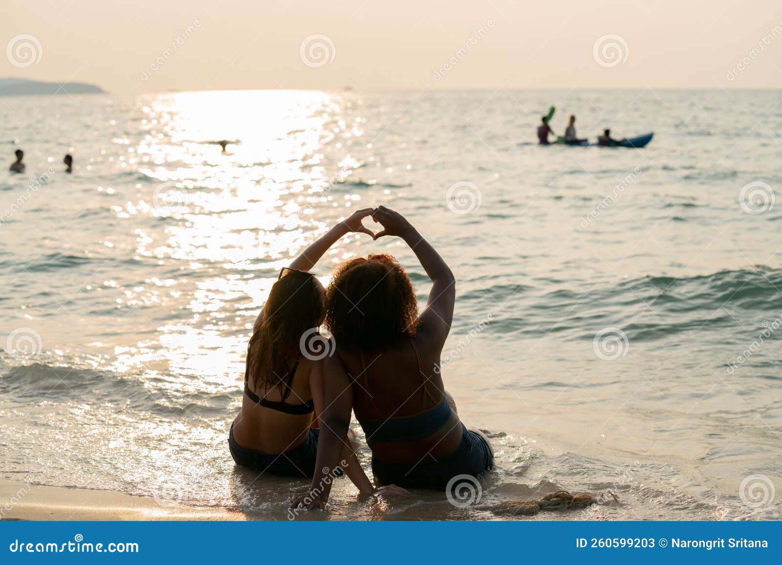 Twee Tienermeisjes Zitten Dicht Bij Elkaar Op Het Strand En Gebruiken ... Twee Tienermeisjes Zitten Dicht Bij Elkaar Op Het Strand En Gebruiken ...