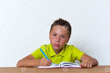 Tween Boy Sitting at the Table with Exercise Book Stock Image - Image ...