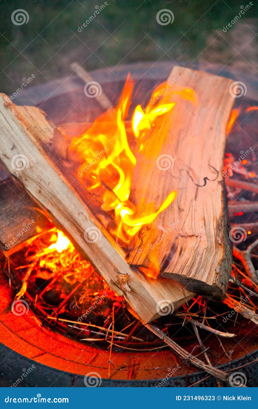Twilight Fire in a Pit with Logs on Top of Curling Flame Stock Image ...