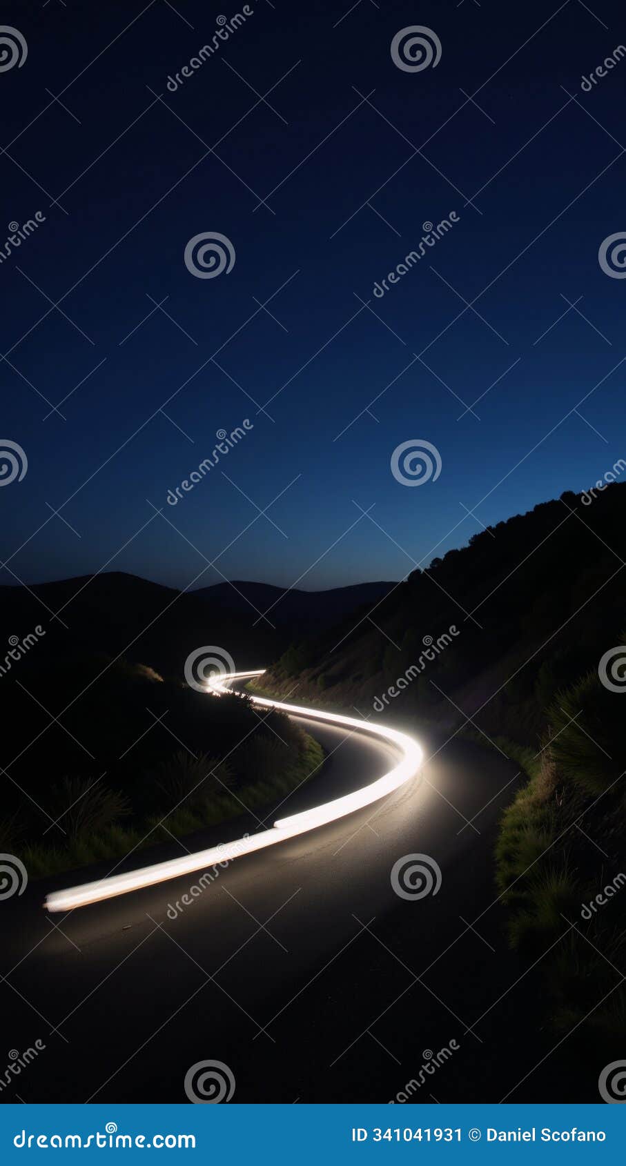 A Twilight Road with Headlightlit Curves Set Amidst a Starry Night Sky ...