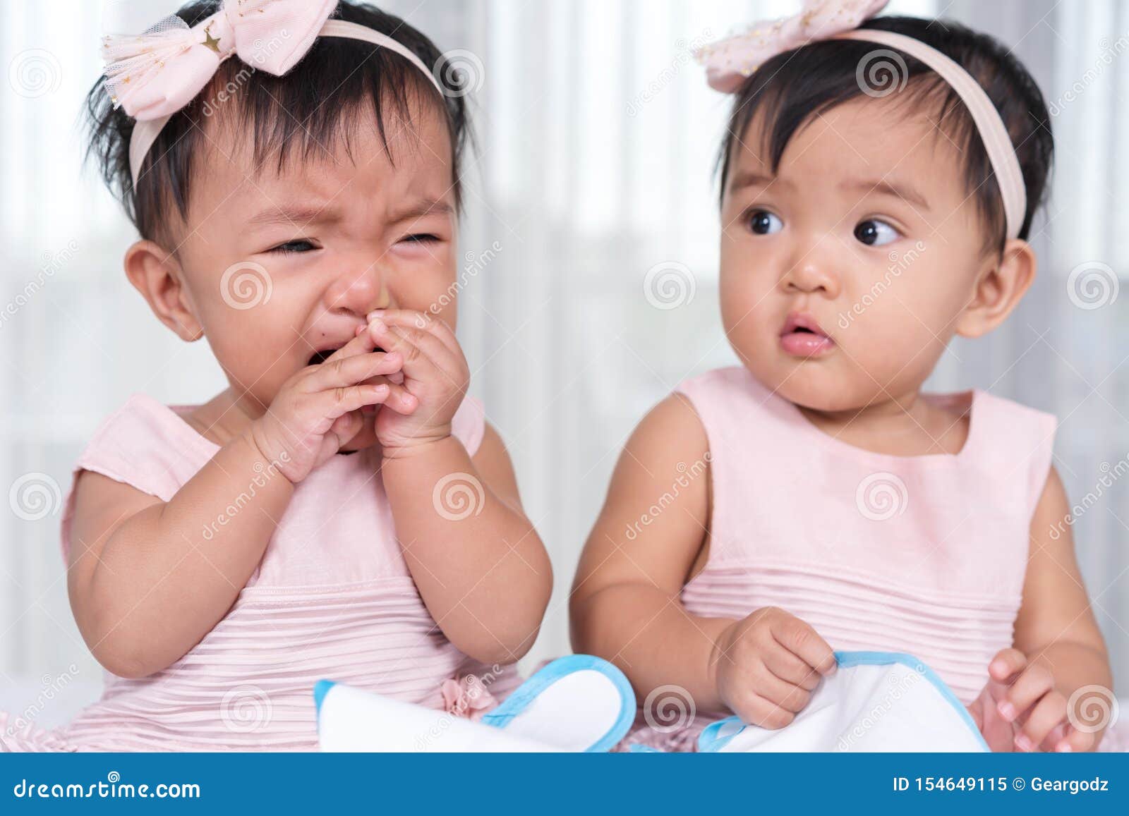 Twin Babies in Pink Dress, One Looking, One Crying Stock Image - Image ...