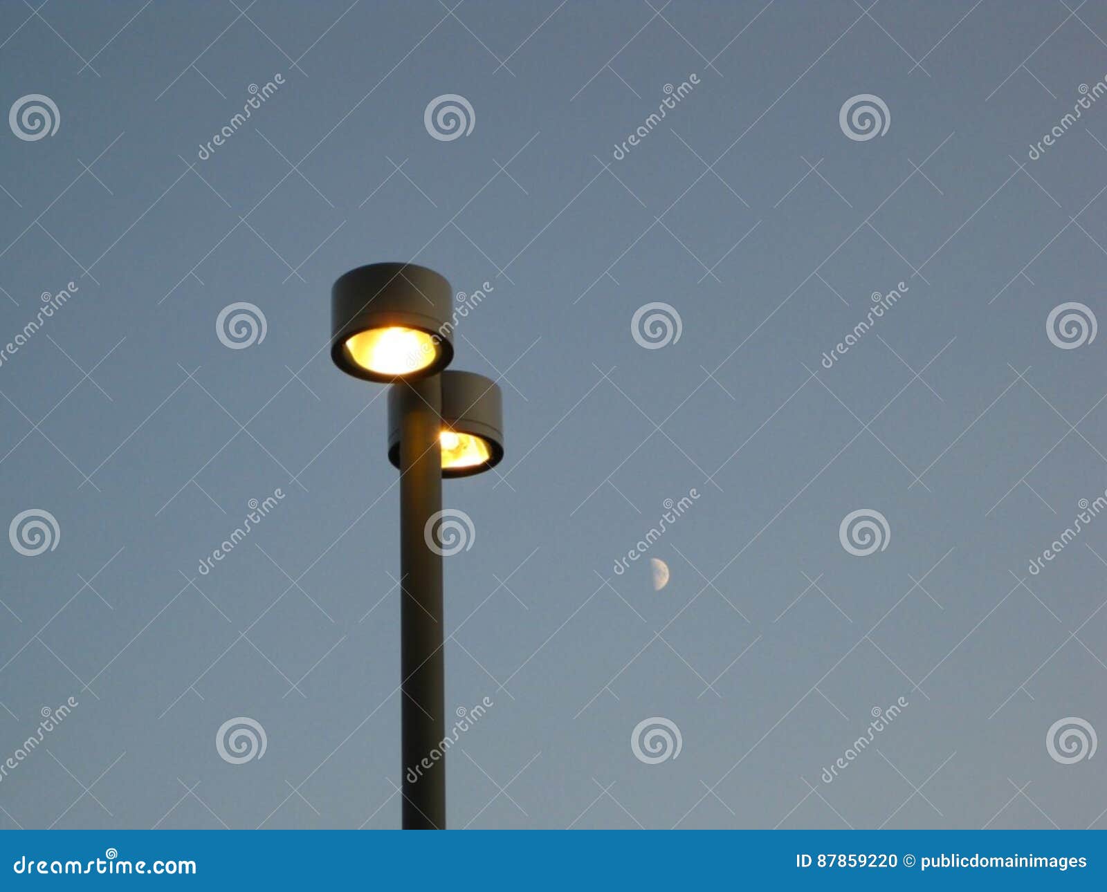 Twin-lamp-post-and-half-moon-in-the-background Picture. Image: 87859220