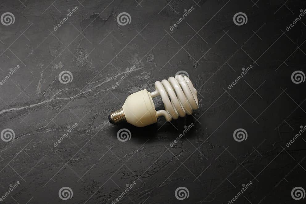 Twisted Lightbulb on a Black Surface Stock Photo - Image of technology ...