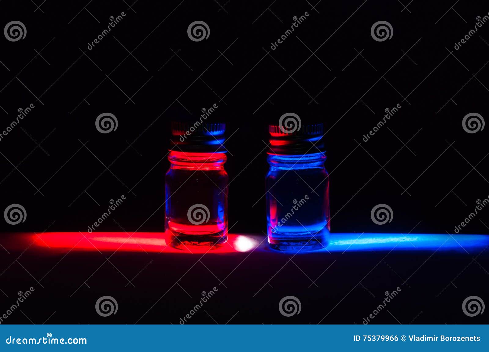 Two Abstract Red and Blue Glass Potions Under Colorful Light Stock ...