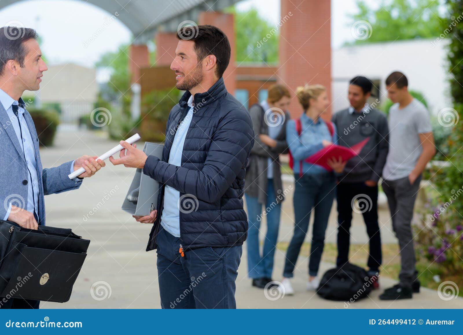 Two Adult Men on Campus Passing Papers Stock Photo - Image of showing ...