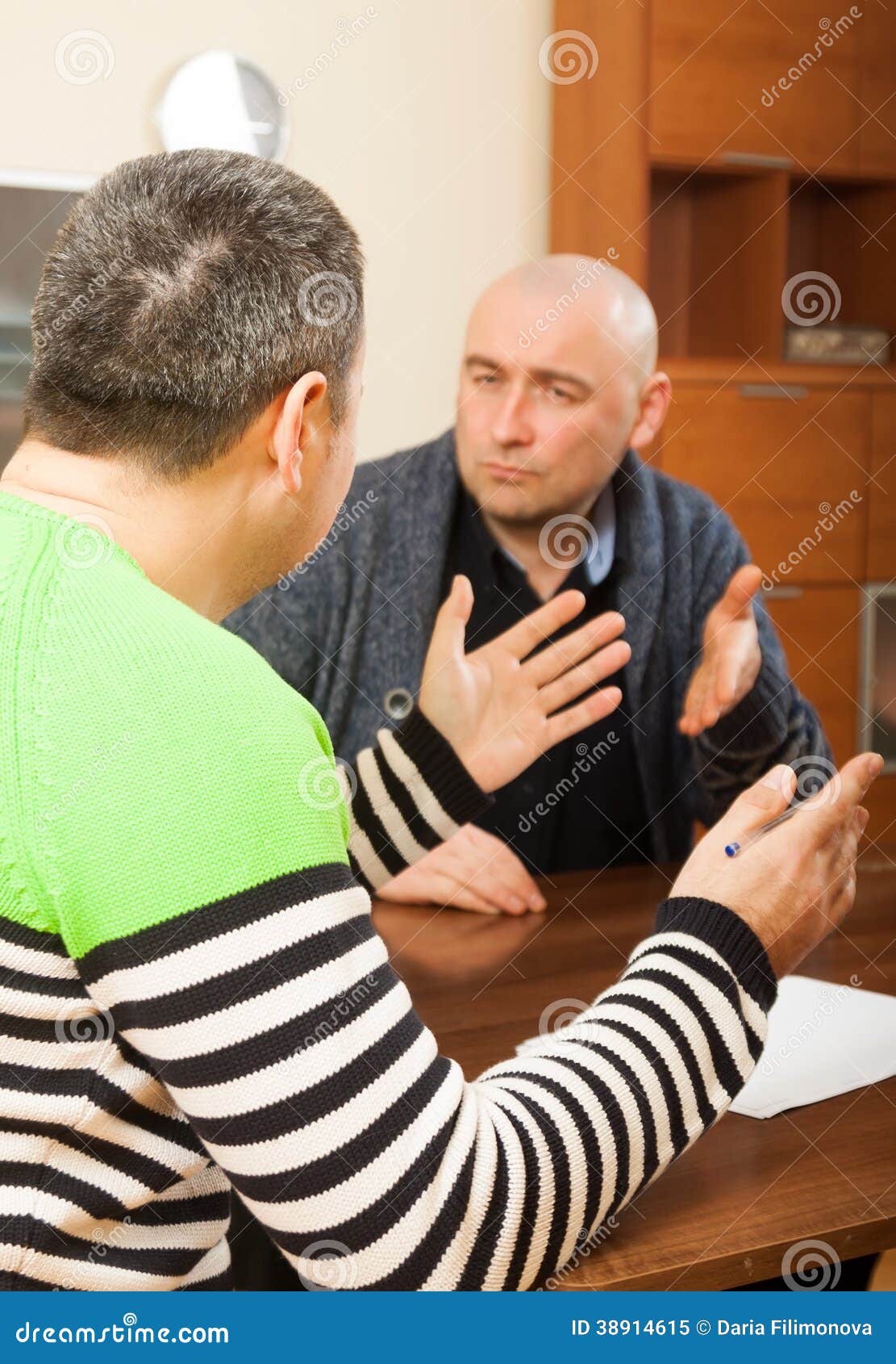 Two Adult Men Discussing Something at Table Stock Image - Image of ...