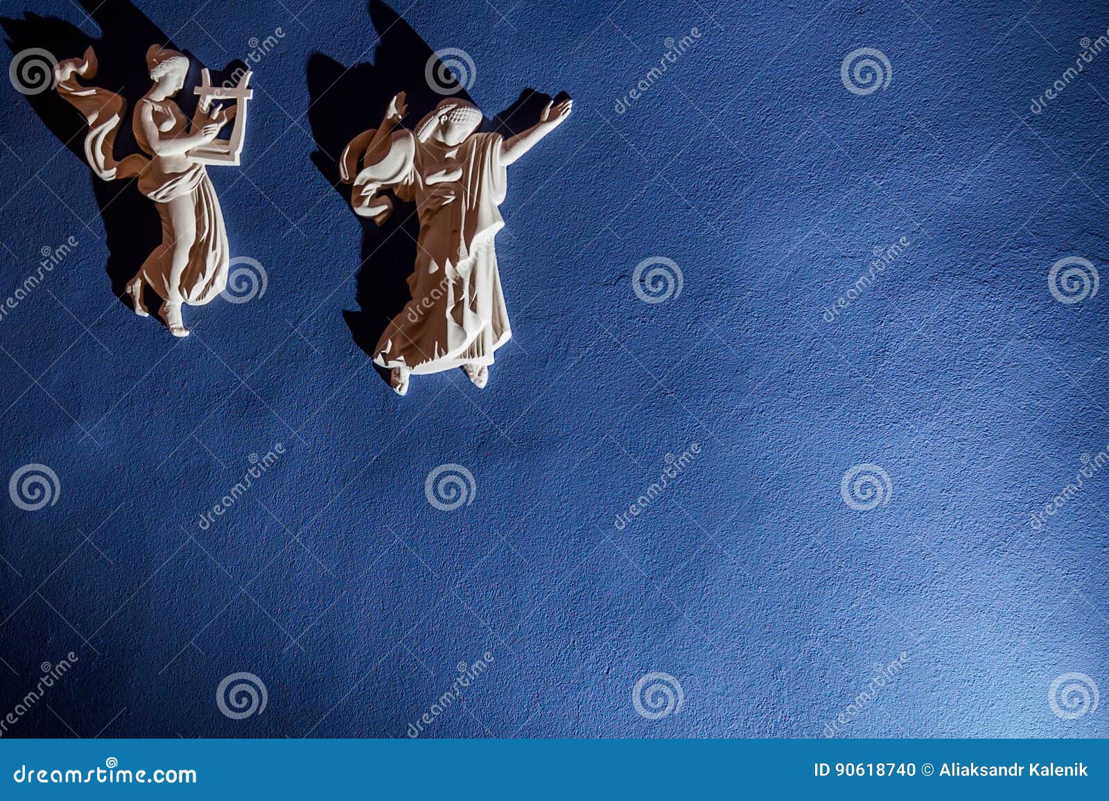Two Antique Figures on a Blue Statue Wall Stock Photo - Image of dark ...