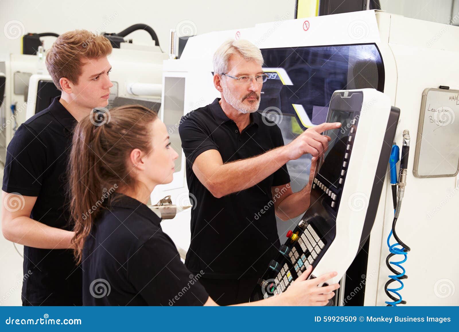Two Apprentices Working with Engineer on CNC Machinery Stock Image ...