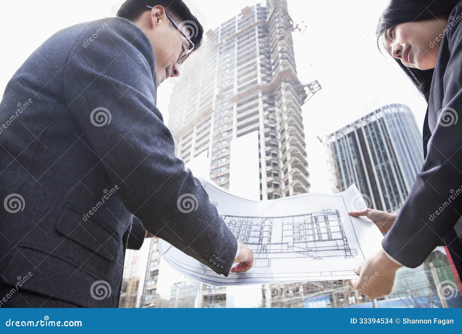 Two Architects Looking at Blueprint at a Construction Site Stock Photo ...