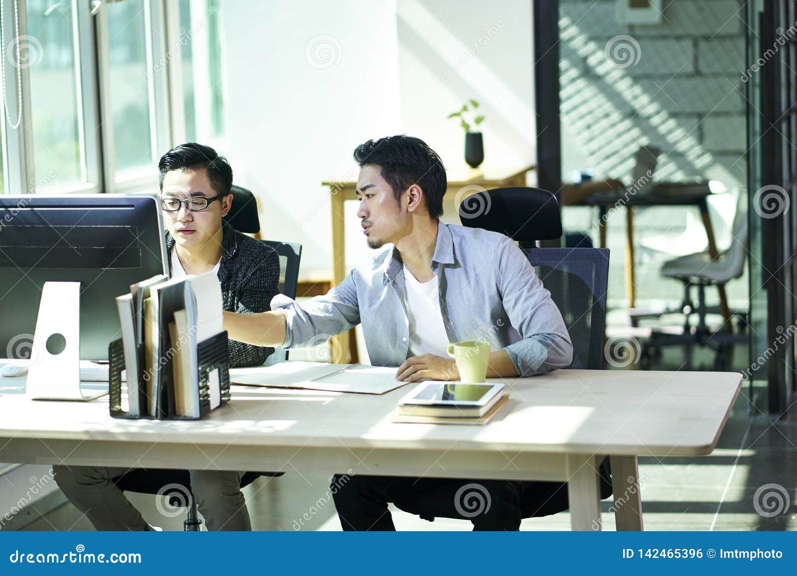 Two Asian Business People Working Together in Office Stock Photo ...