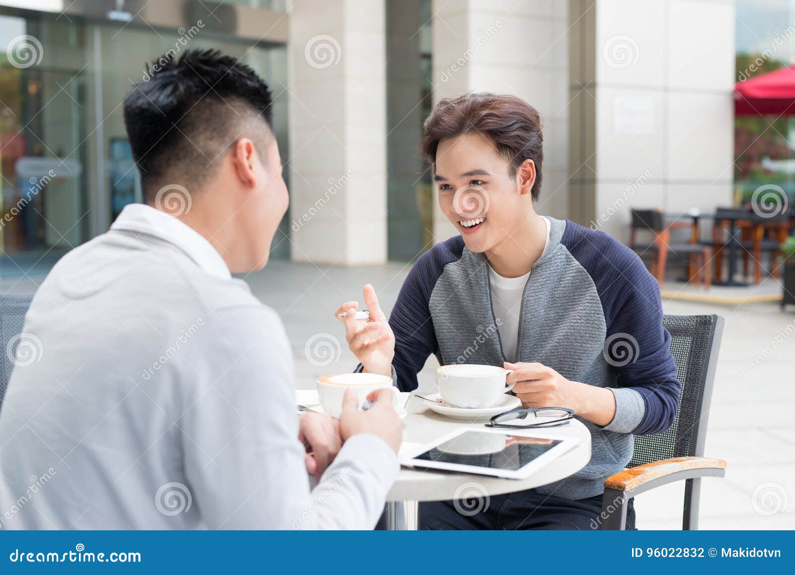 Two Asian Man Sitting in Cafe and Discussing Stock Photo - Image of ...