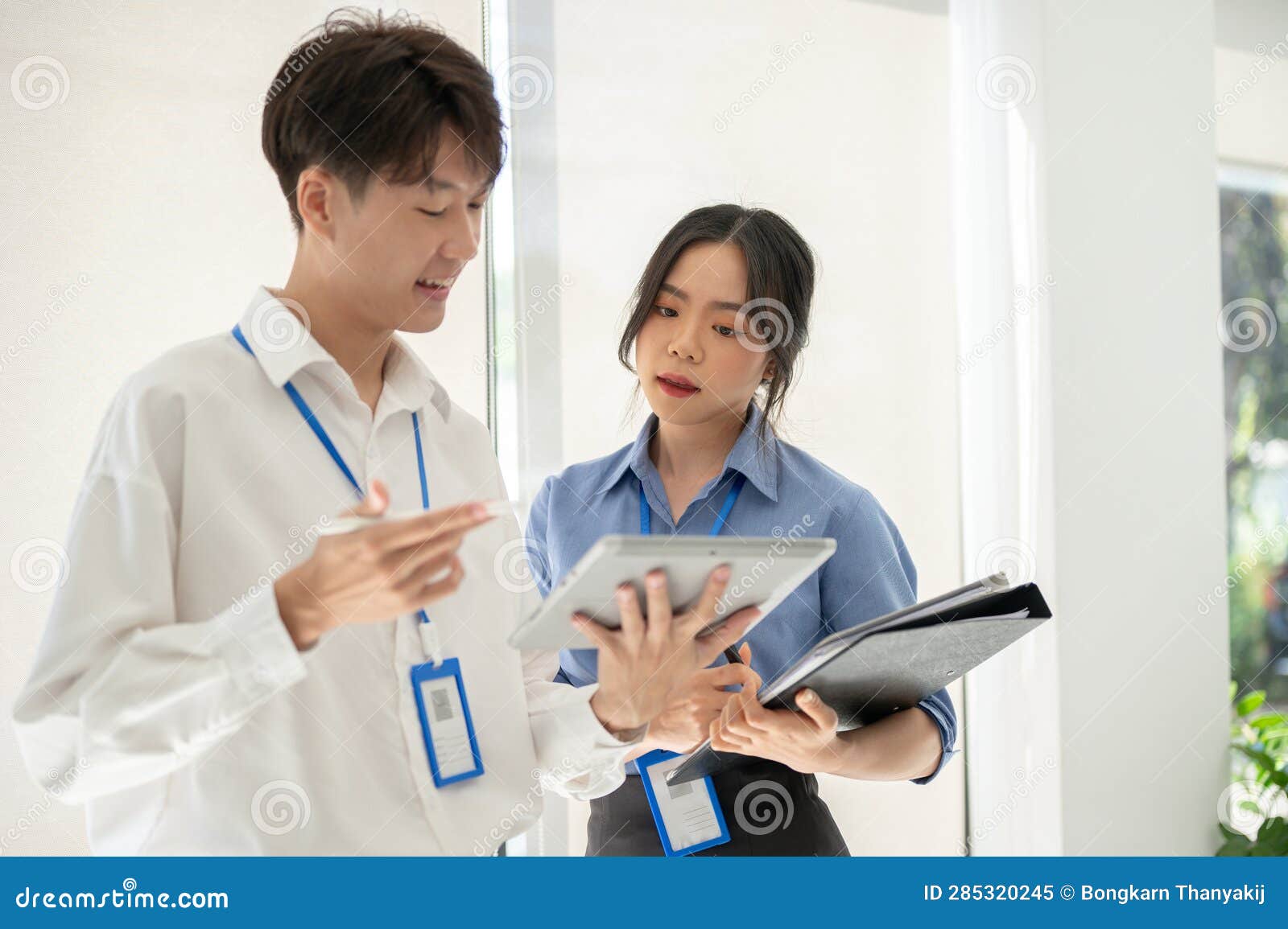 Two Asian Office Workers are Talking and Discussing Work while Standing ...