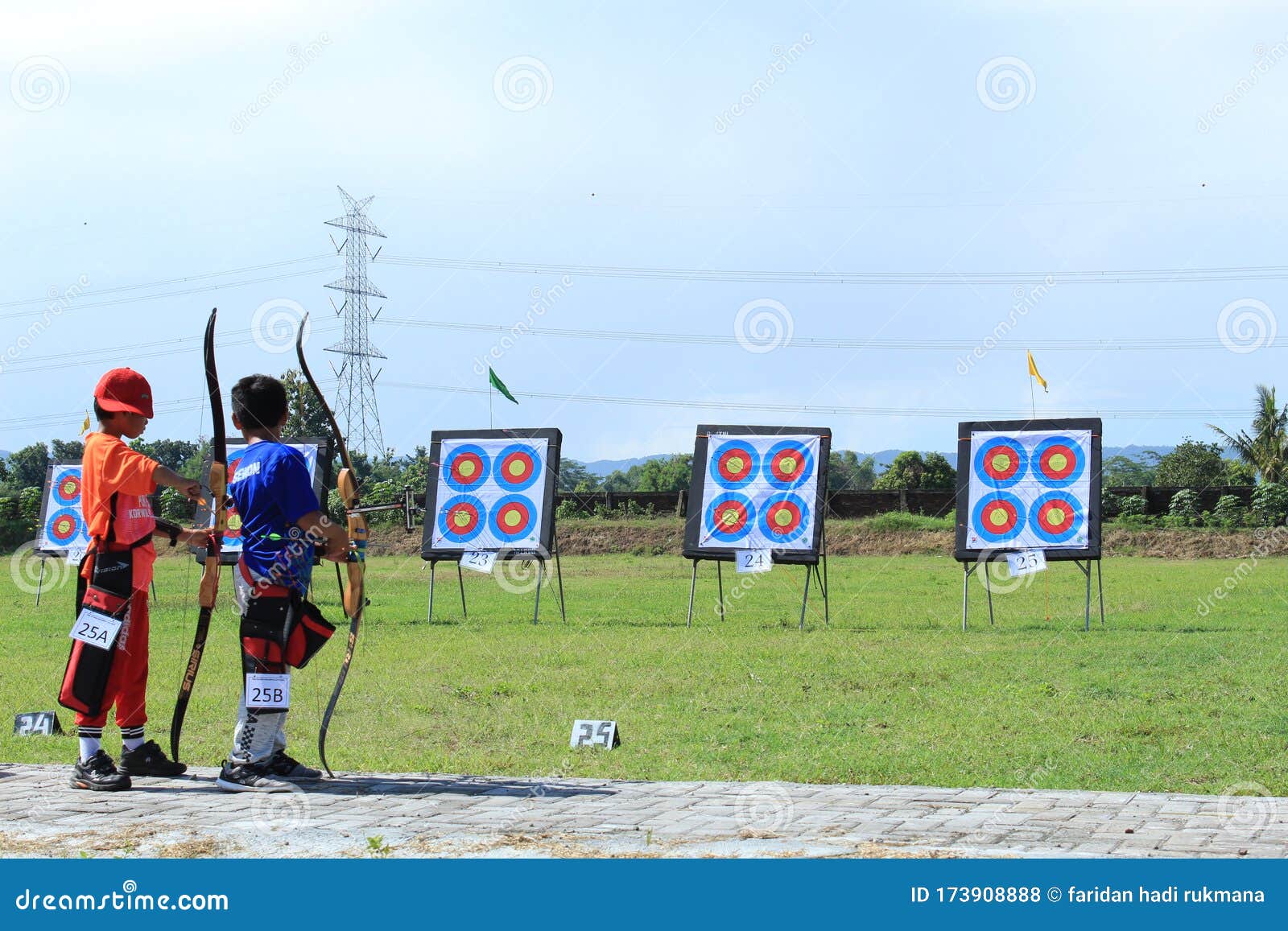 Two Athletes Practicing Archery Against a Background of a Clear Blue ...