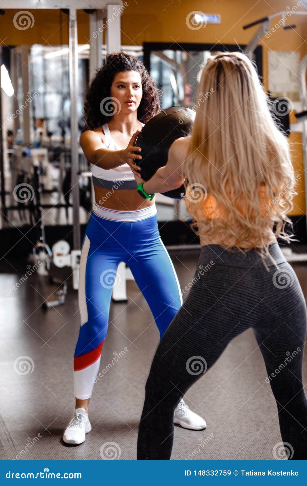 Two Athletic Girls Dressed In A Sportswear Are Doing Together Back