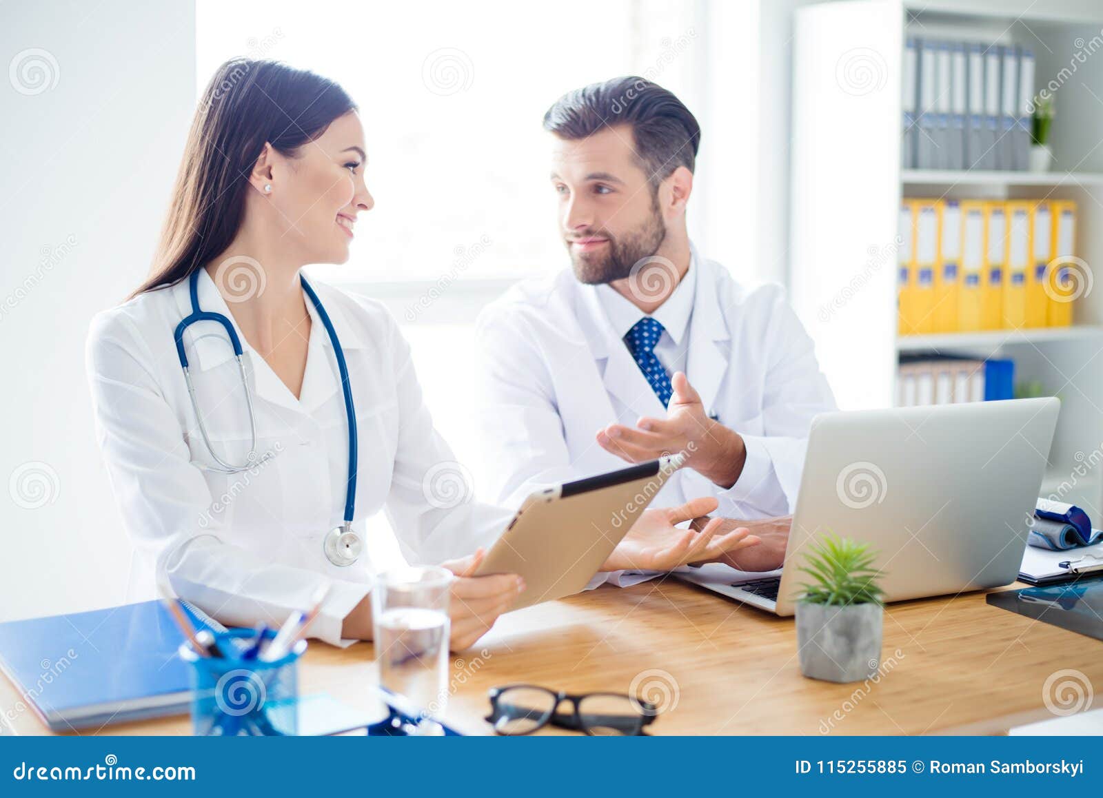 Two Attractive Young Doctors Using Computer and Discussing Thei Stock ...