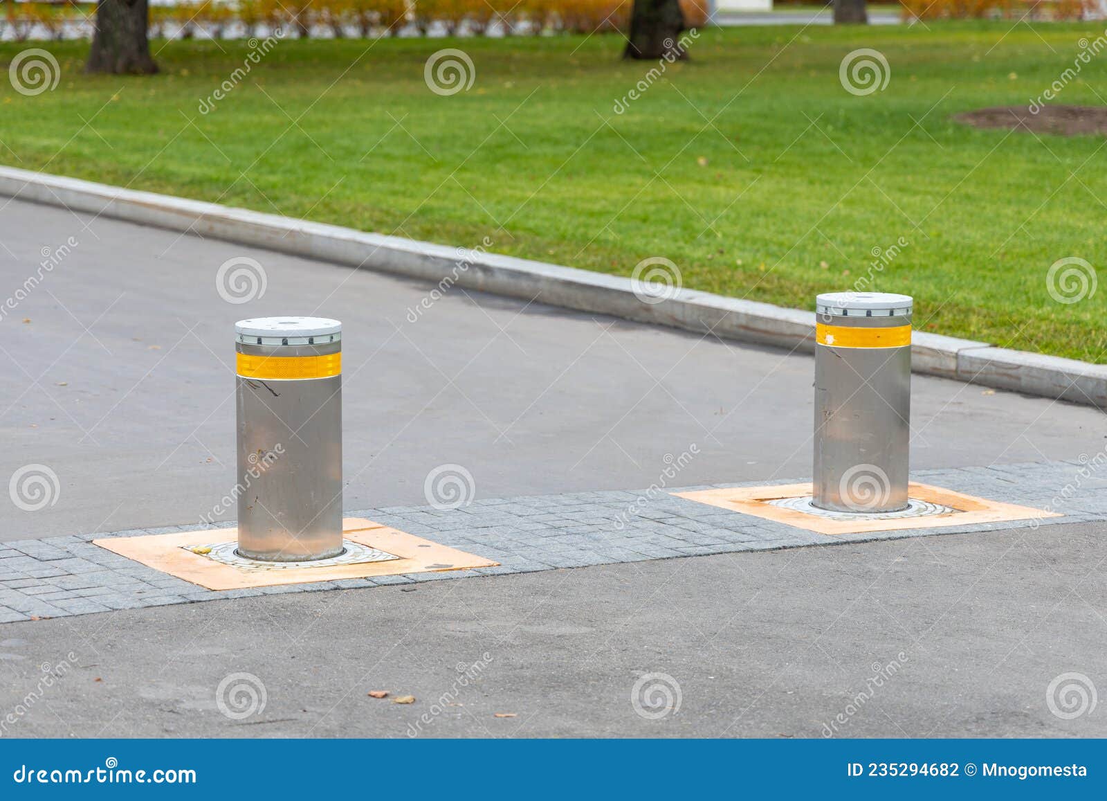Two Automatic Security Bollards on the Asphalt Road. Pillars for Safe ...