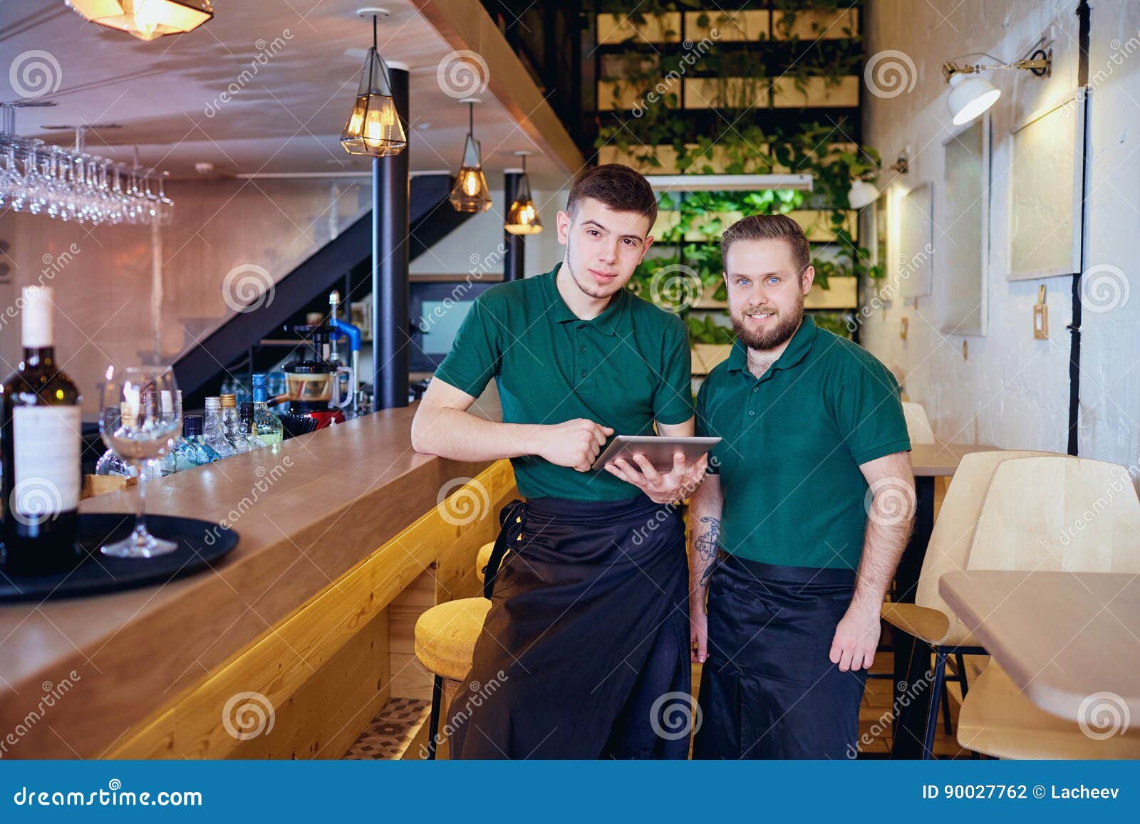 Two Bartenders Waiter with a Gadget Tablet in Bar Stock Photo - Image ...